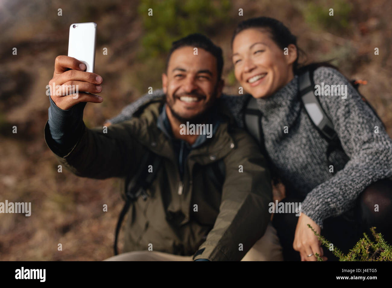 Young couple hiking taking selfie with smart phone. Happy young man and ...