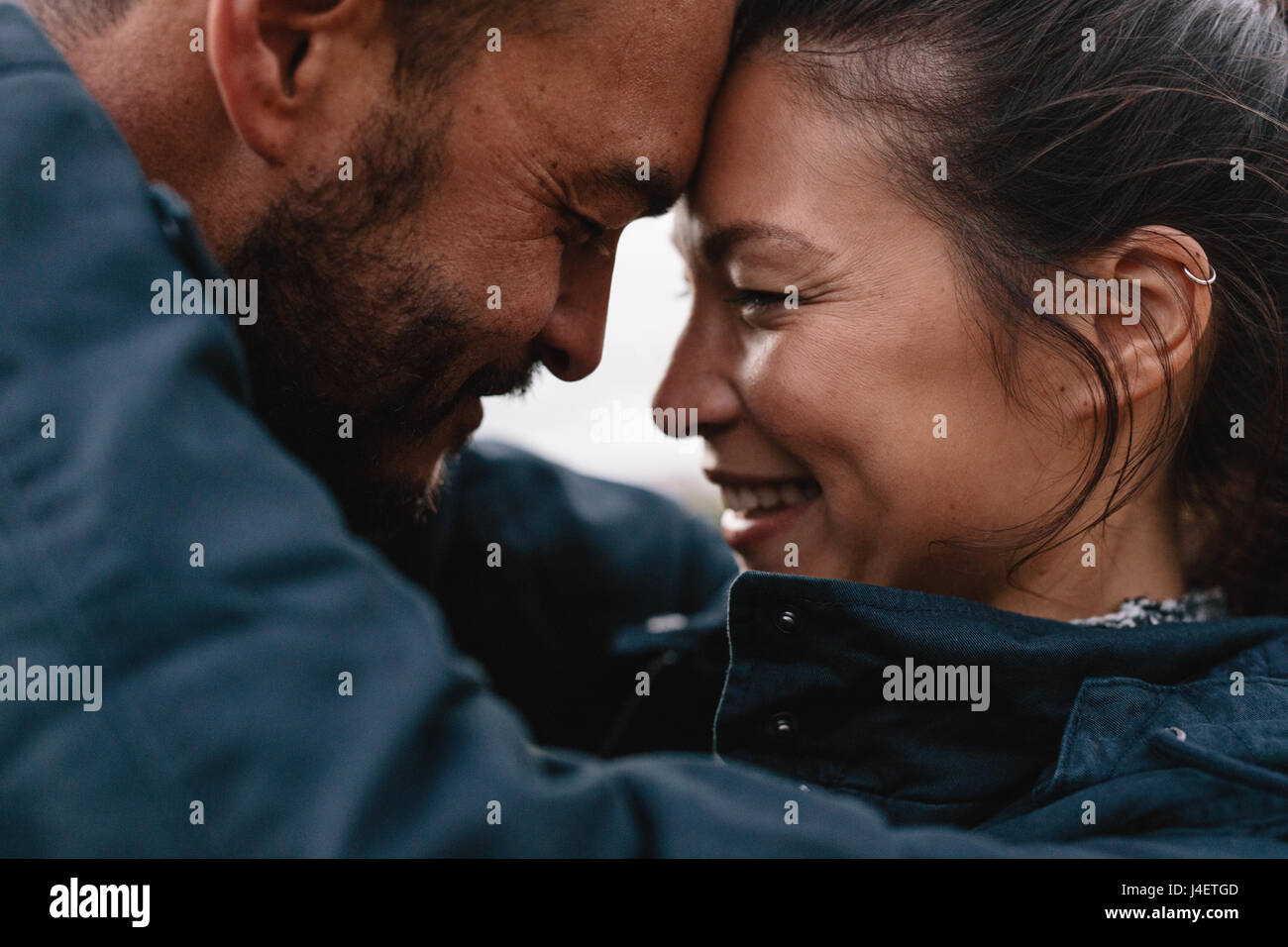Close-up side portrait of young mixed race couple in love. Romantic ...