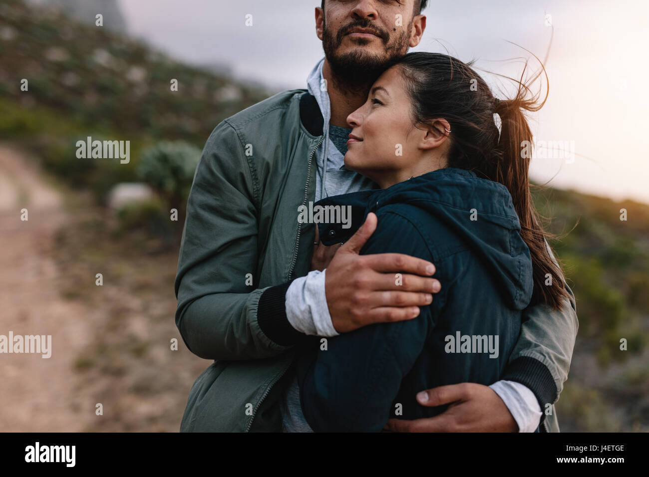 Romantic young couple embracing during hike in countryside. Loving ...