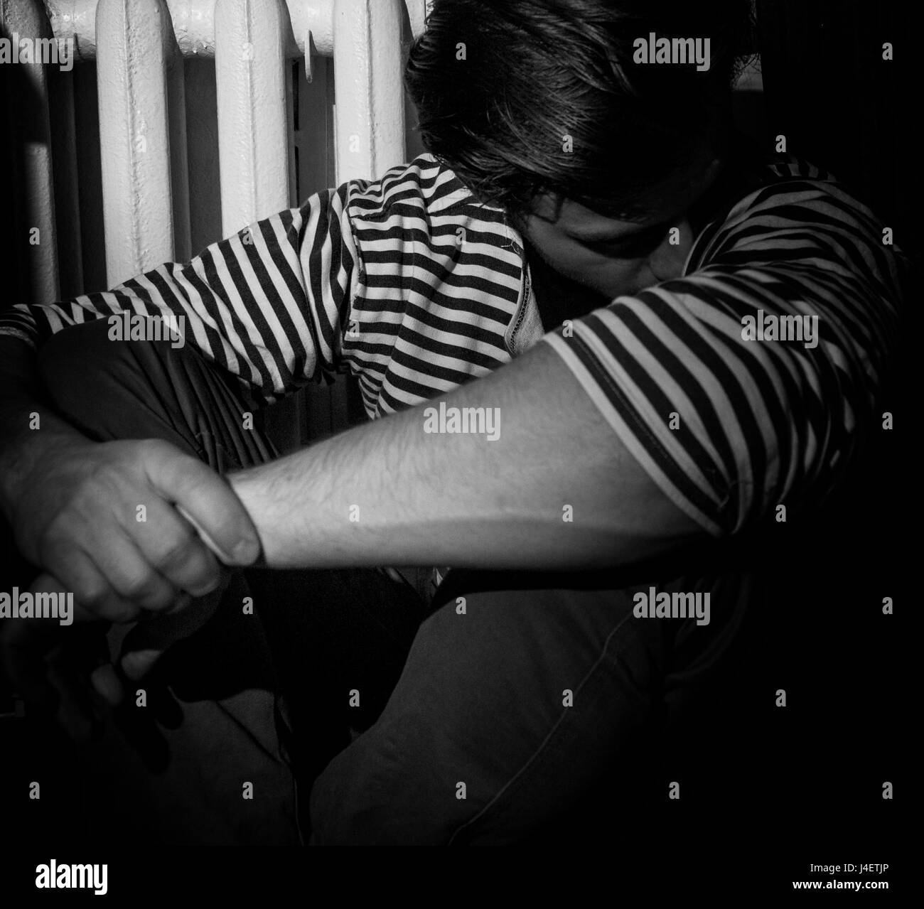 Boy sitting head down sad hi-res stock photography and images - Alamy