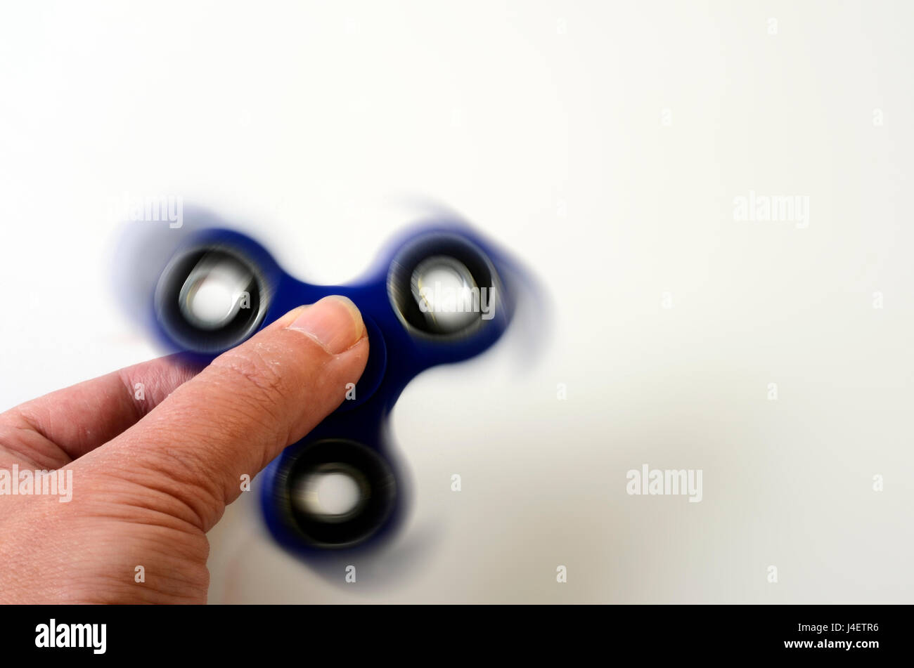 Blue Hand spinner, fidgeting hand toy rotating on fingers Stock Photo ...