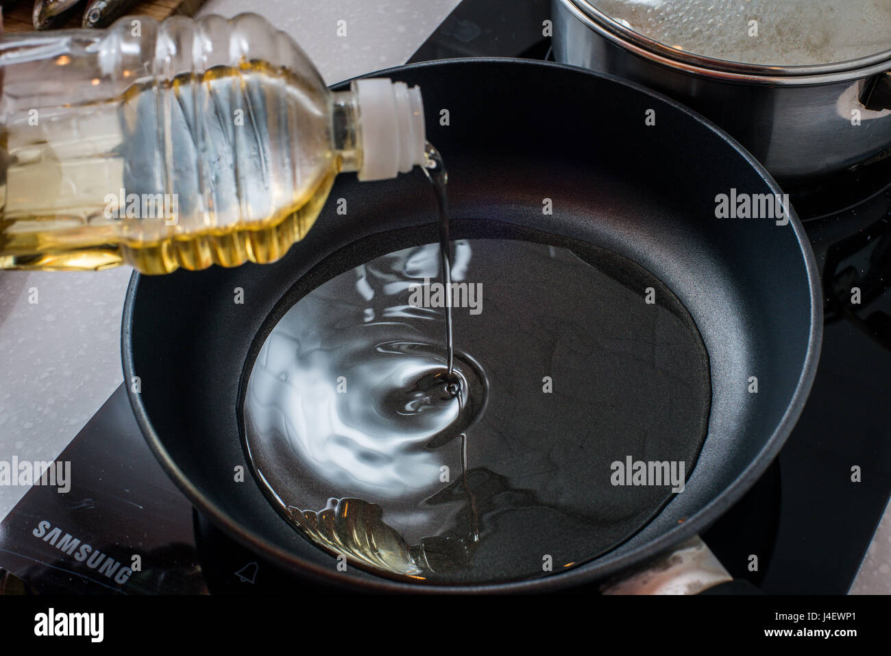 Chef pouring vegetable oil to the pan Stock Photo - Alamy