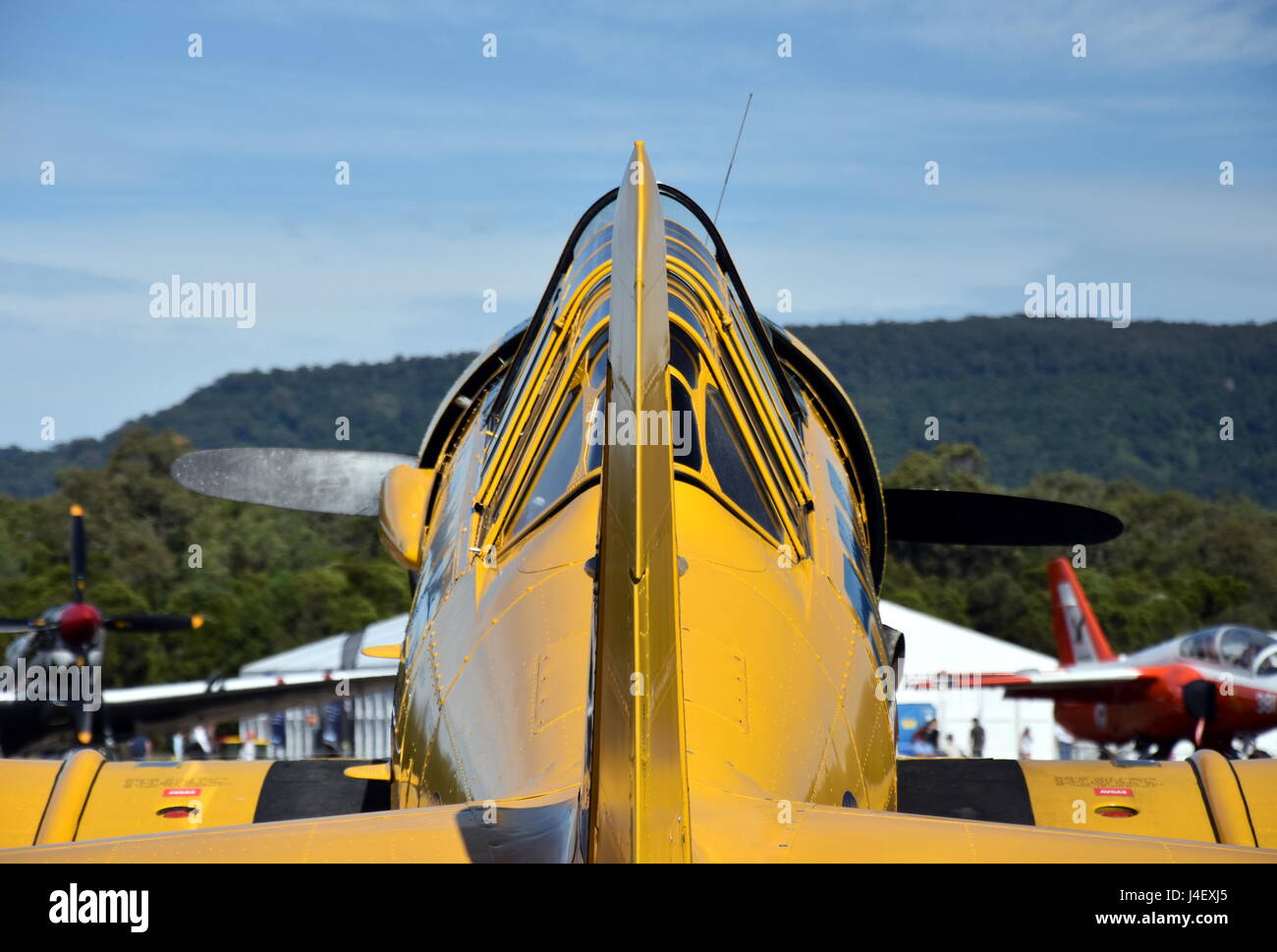 Closeup of a yellow airplane. View behind the cockpit from the wings ...
