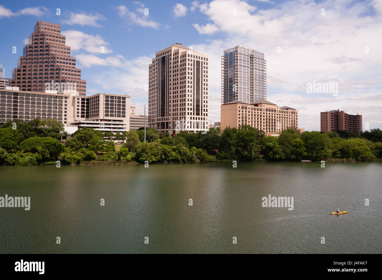 A yellow kayak floats along through Austin on the riverfront Stock ...