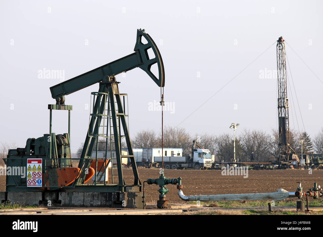 oilfield with pump jack and oil drilling rig Stock Photo - Alamy