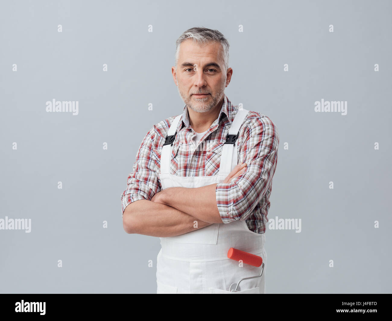 Confident painter posing with arms crossed and looking at camera Stock ...