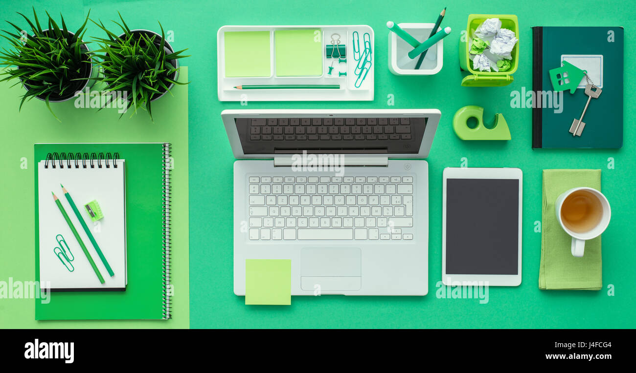 Green creative and eco-friendly desktop with laptop and office ...