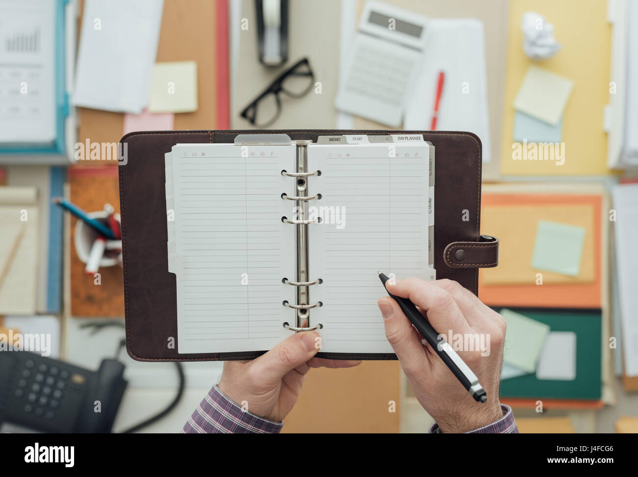 Businessman scheduling appointments on his organizer, full business ...