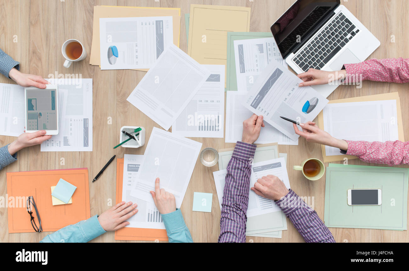 Business team working at office desk with paperwork, a laptop and a ...