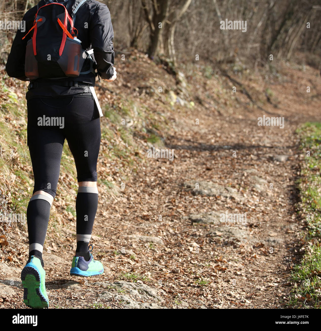 Leg of athlete runner during racing on the mountain trail in winter ...