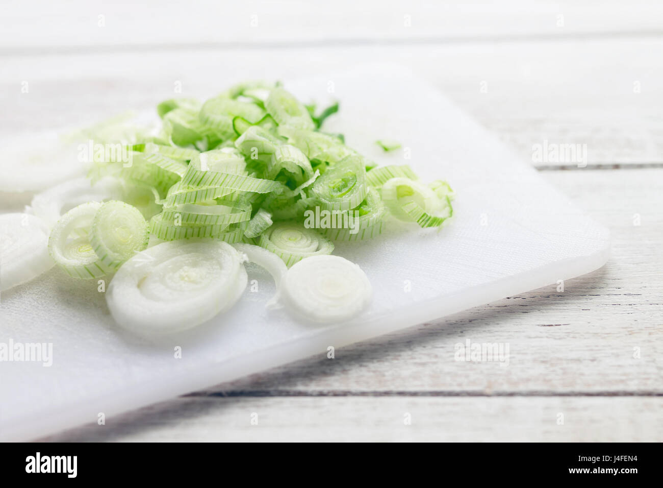 Chopped spring onions on a white board Stock Photo - Alamy