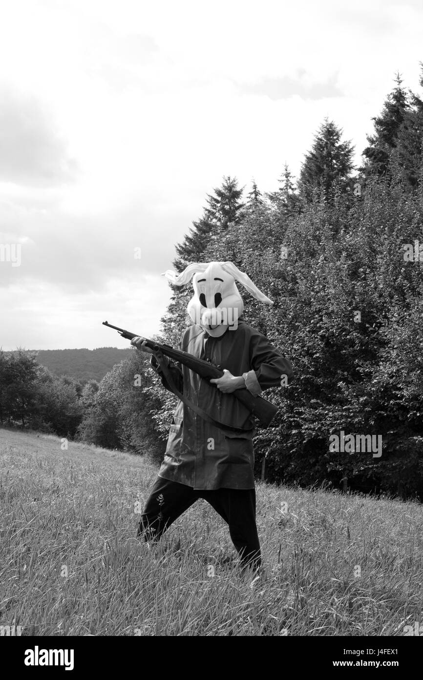 black and white photography. woman hunter wearing a rabbit mask hunting ...