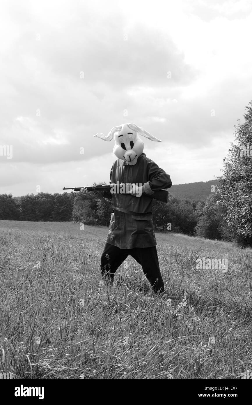 black and white photography. woman hunter wearing a rabbit mask hunting ...