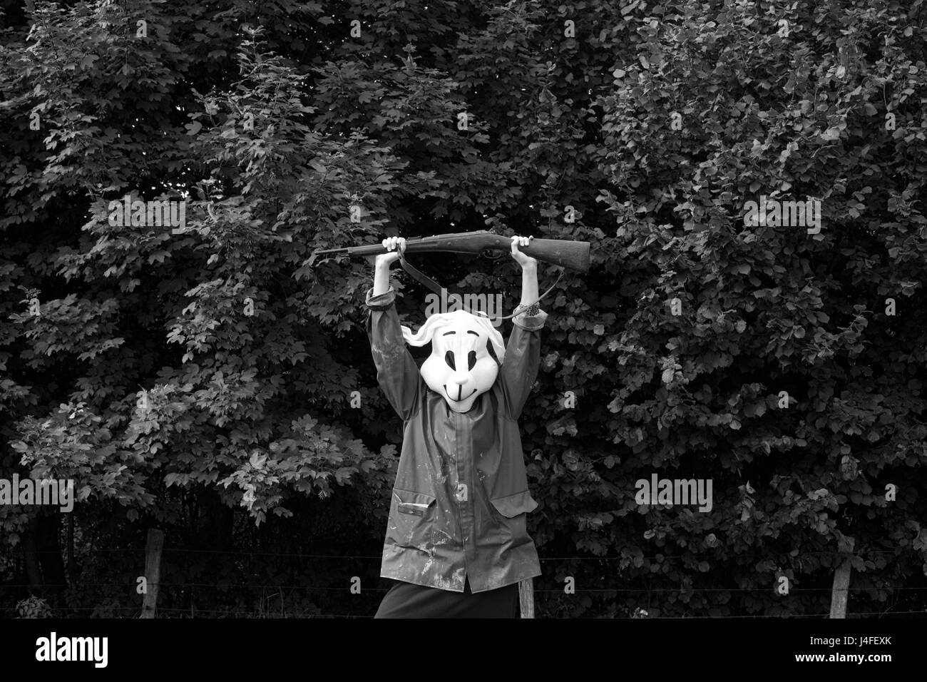 black and white photography. woman hunter wearing a rabbit mask hunting ...
