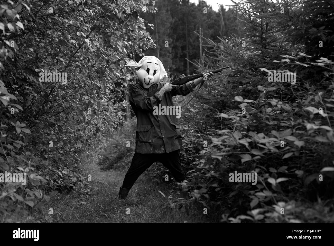 black and white photography. woman hunter wearing a rabbit mask hunting ...