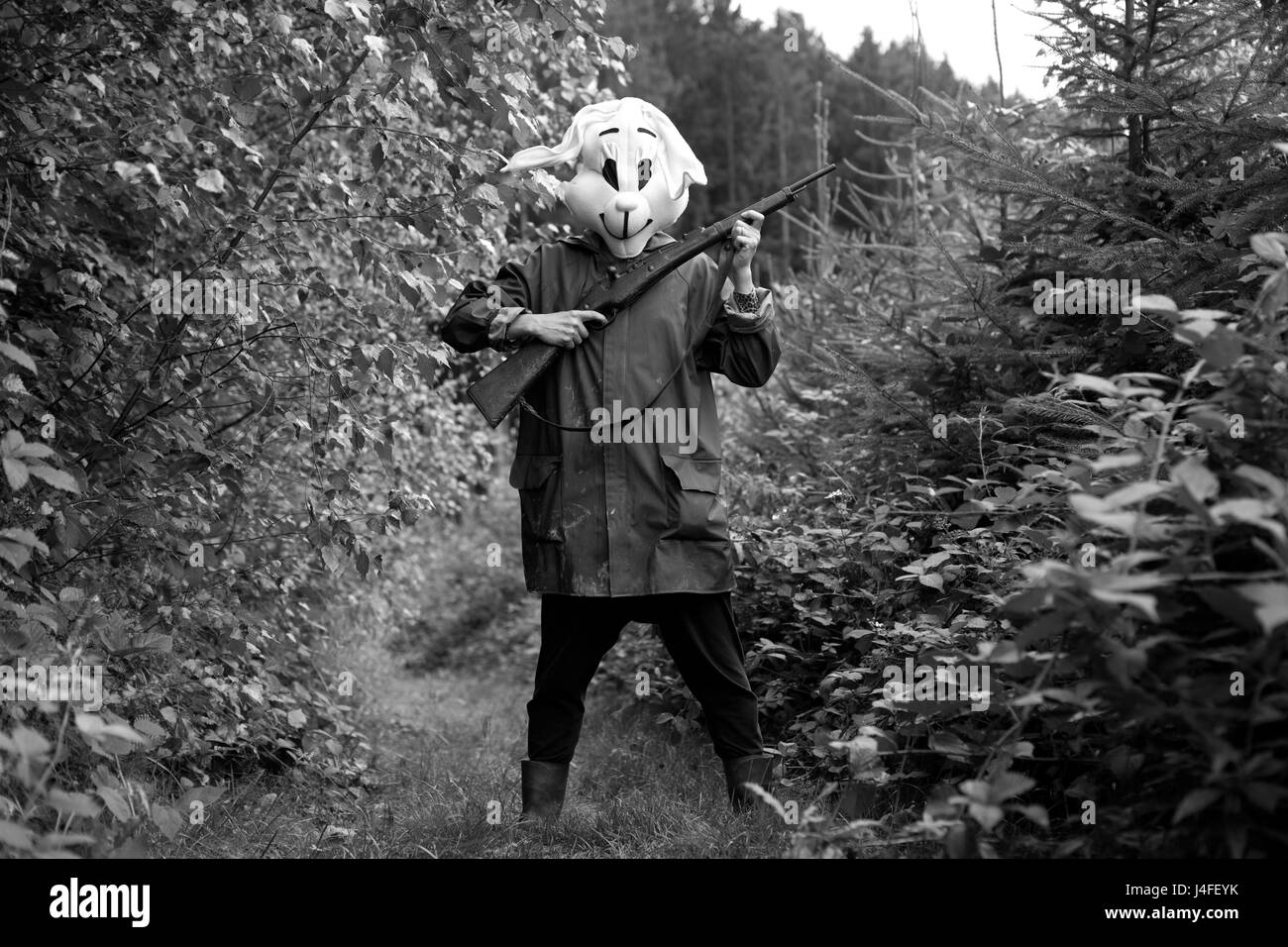 black and white photography. woman hunter wearing a rabbit mask hunting ...