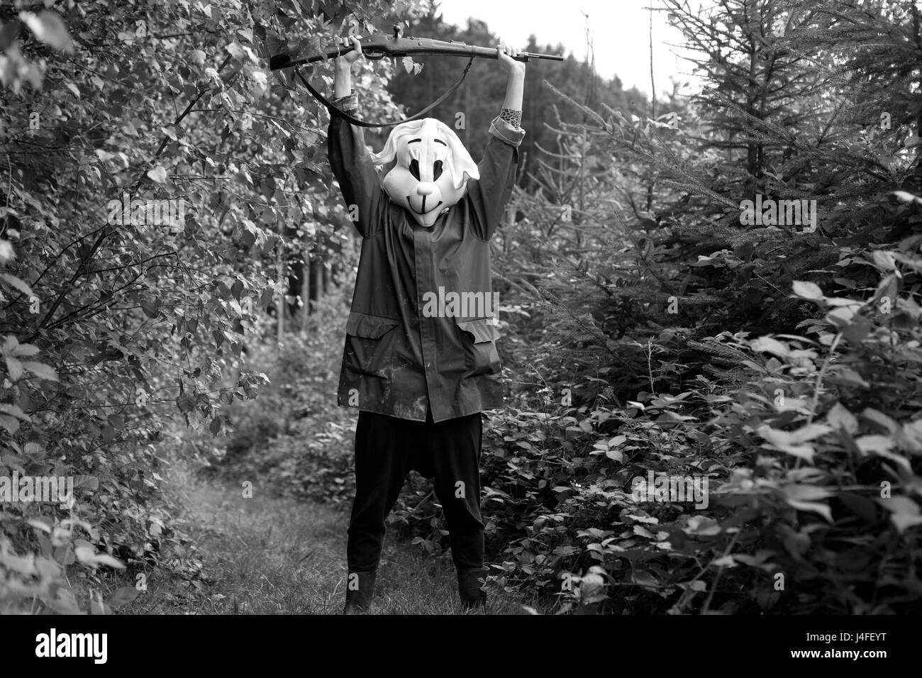 black and white photography. woman hunter wearing a rabbit mask hunting ...