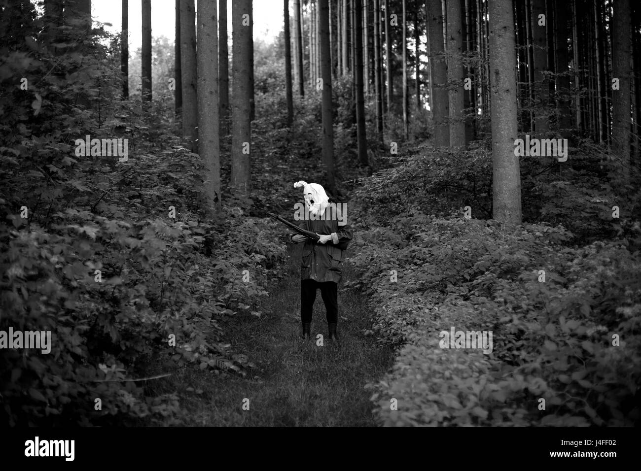 black and white photography. woman hunter wearing a rabbit mask hunting ...
