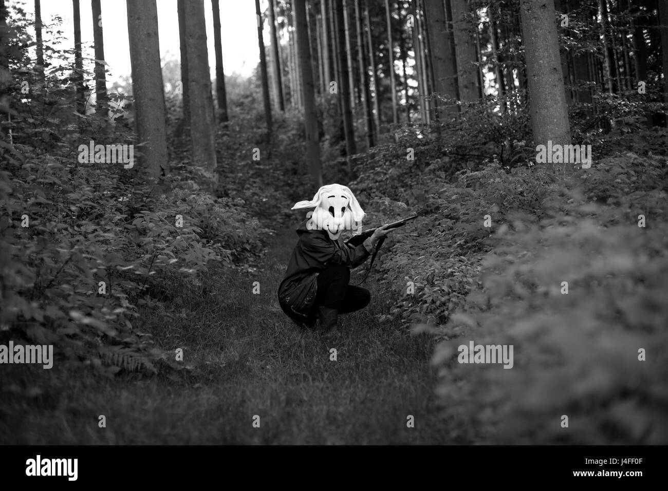 black and white photography. woman hunter wearing a rabbit mask hunting ...