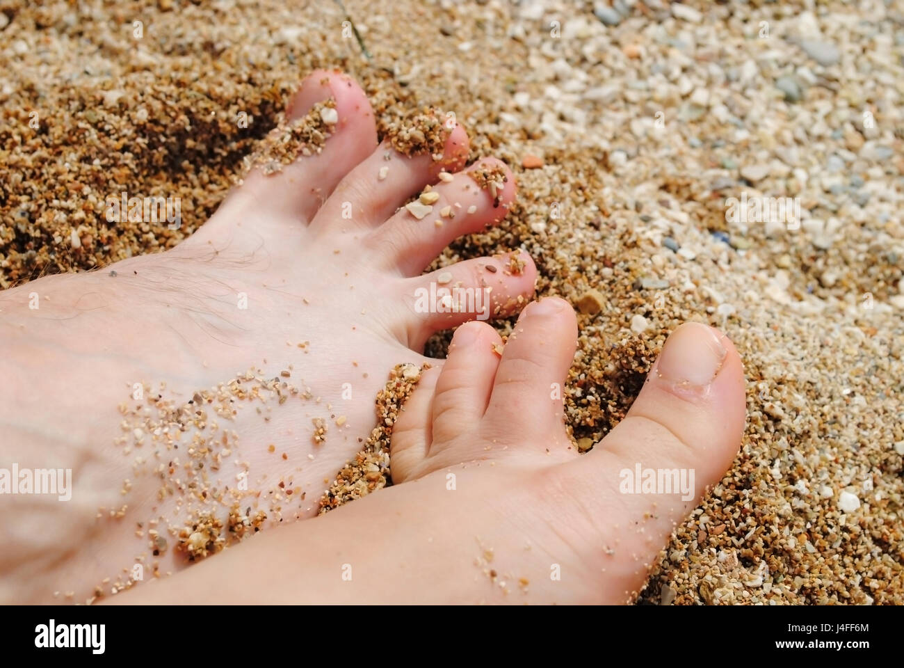 Feet in the sand Stock Photo - Alamy