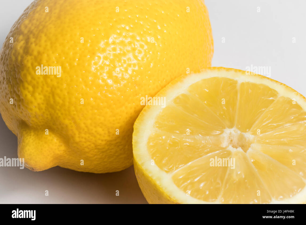 Close up of whole lemon and half lemon on white background Stock Photo ...