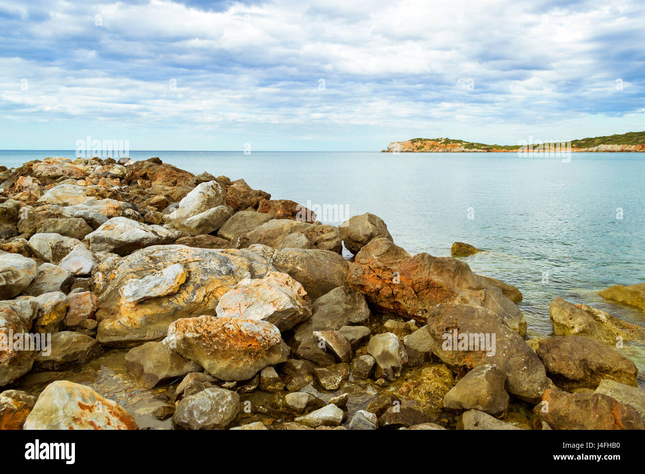 Breakwater of huge rocks going out to sea. Marine spit on beach Livadi ...
