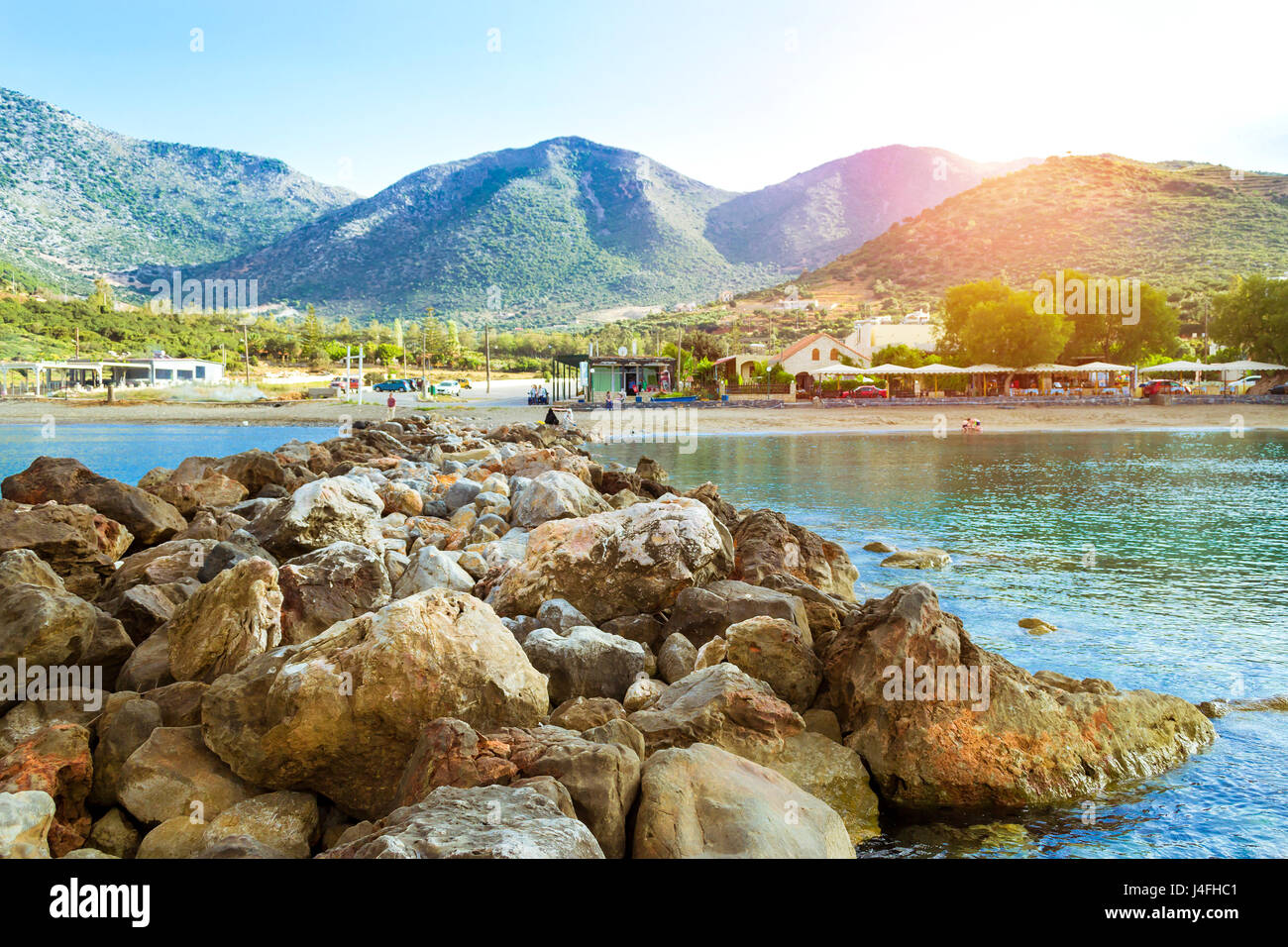 Breakwater of huge rocks going out to sea. Marine spit on beach Livadi ...