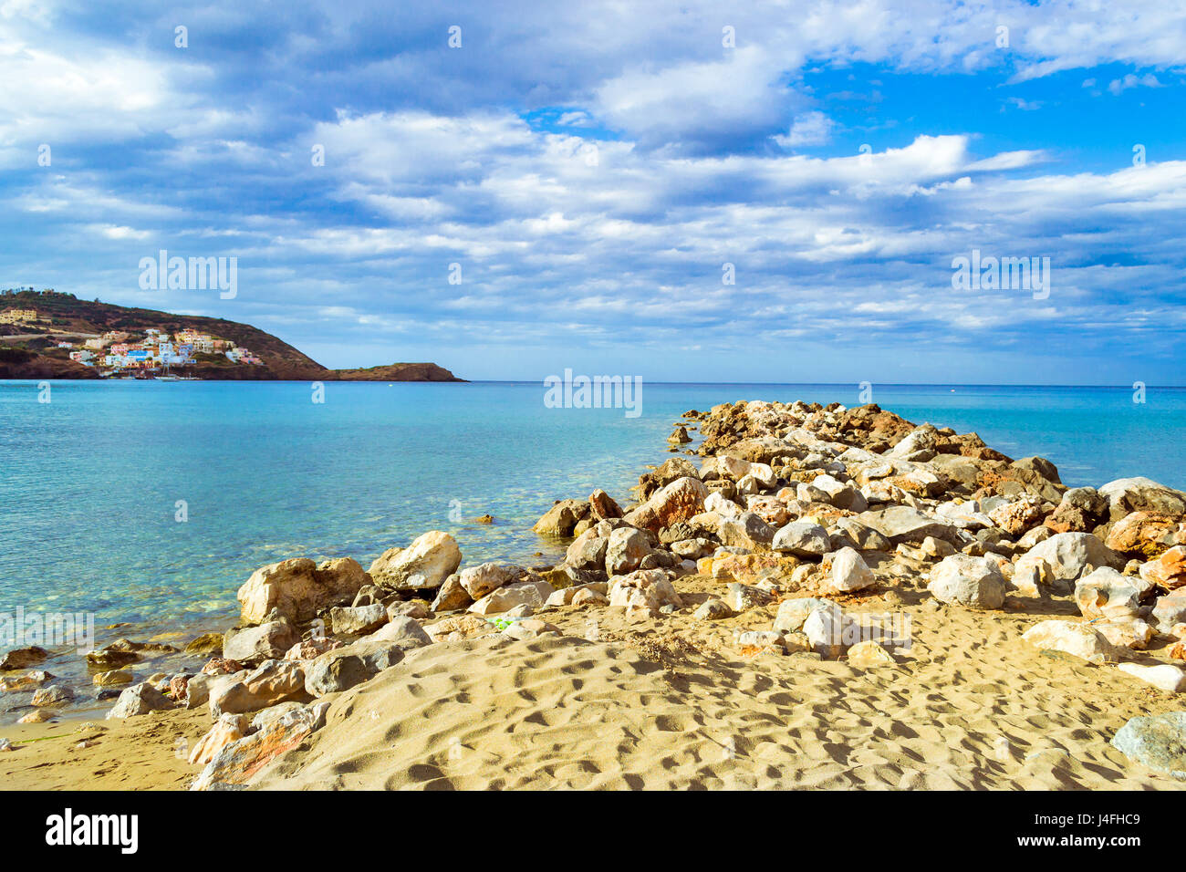 Breakwater of huge rocks going out to sea. Marine spit on beach Livadi ...