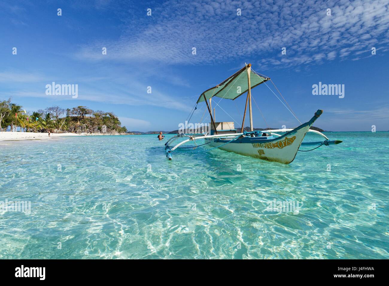 Outrigger boat floating in clear water Stock Photo - Alamy