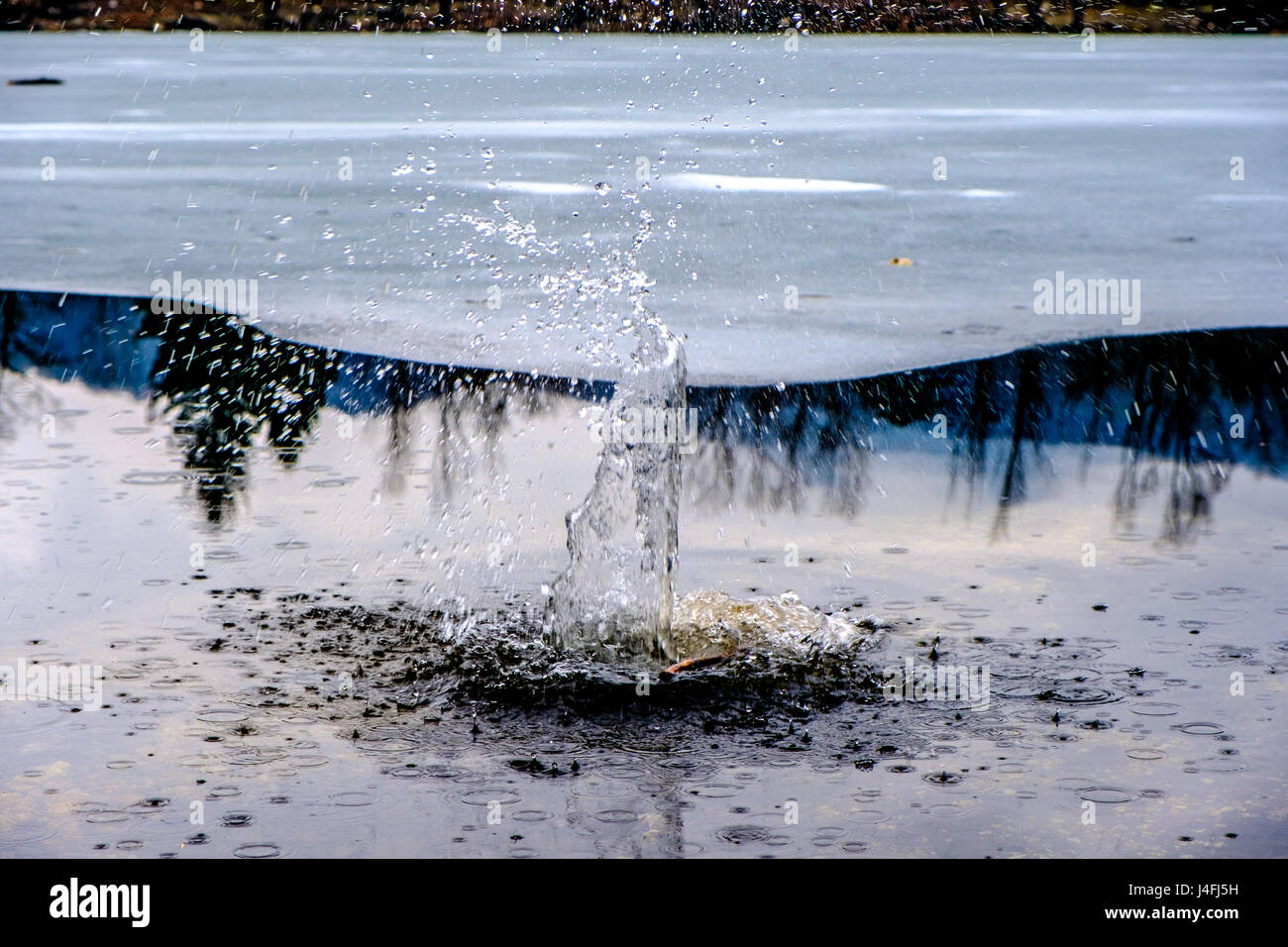 A splash of water jumping from a frozen lake Stock Photo - Alamy