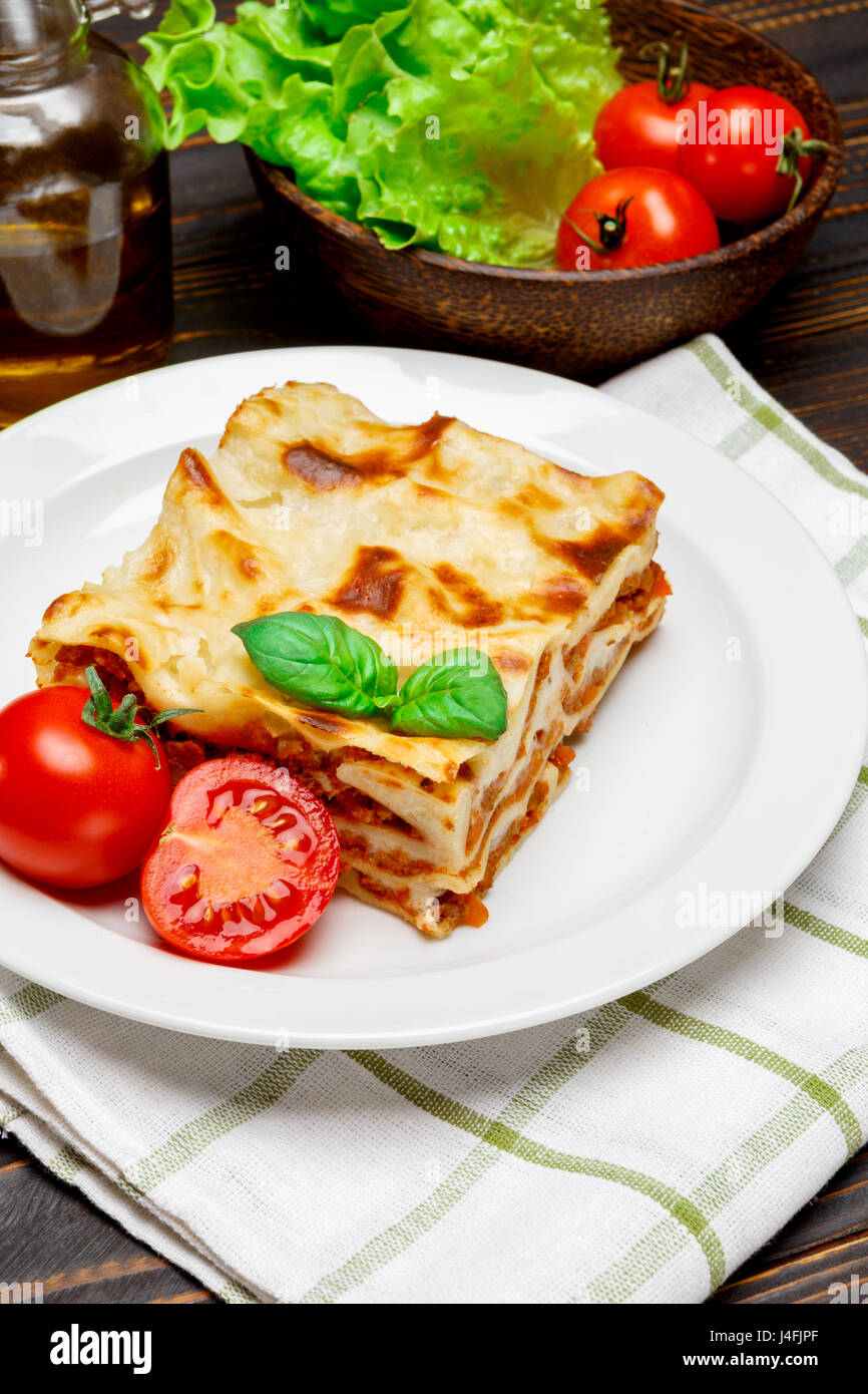 Portion of tasty lasagna on wooden background or table Stock Photo - Alamy