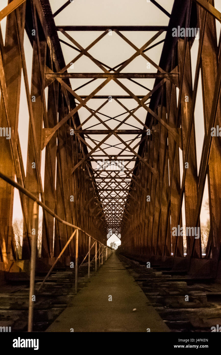Old industrial railway railroad iron bridge center perspective in night ...