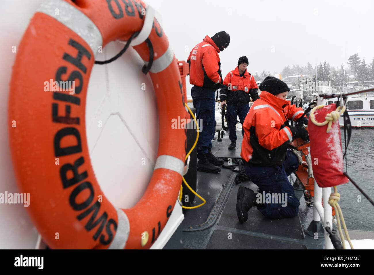 Coast Guard Cutter Swordfish crewmembers wait while fueling the 87-foot ...