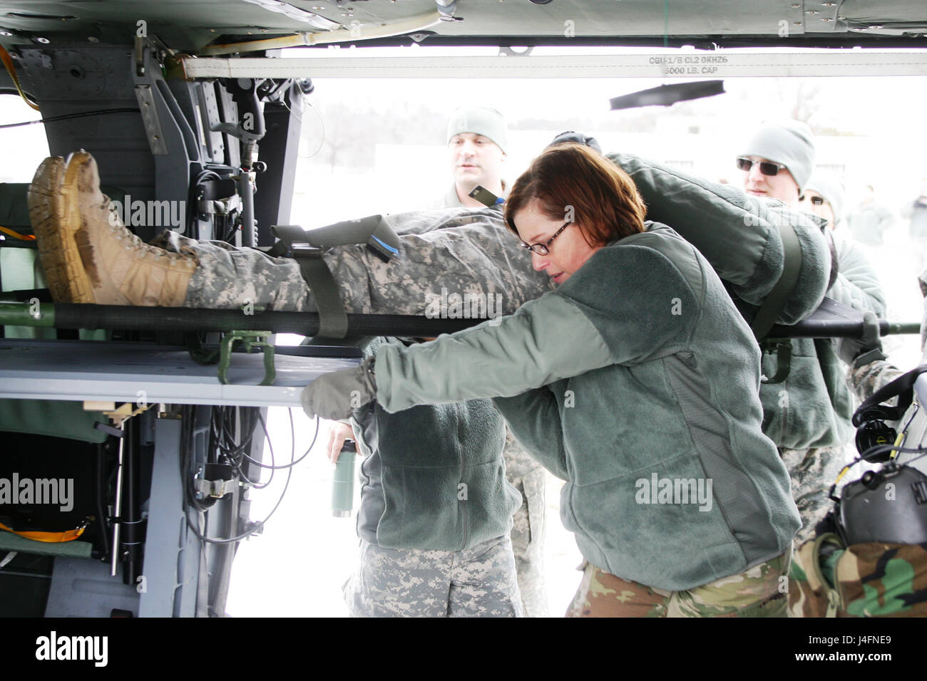 Soldiers practice loading and unloading a simulated patient into a ...