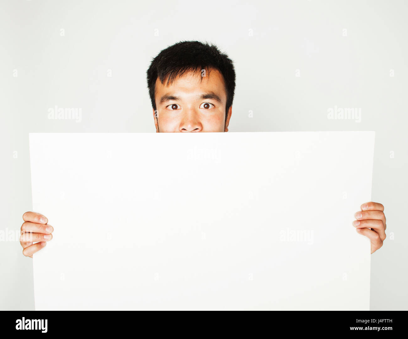 pretty cool asian man holding empty white plate smiling Stock Photo - Alamy
