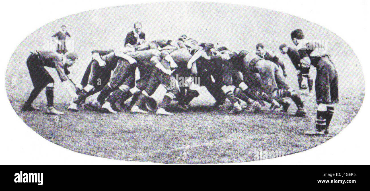 The image depicts a rugby scrum from 1904, capturing the dynamic and ...