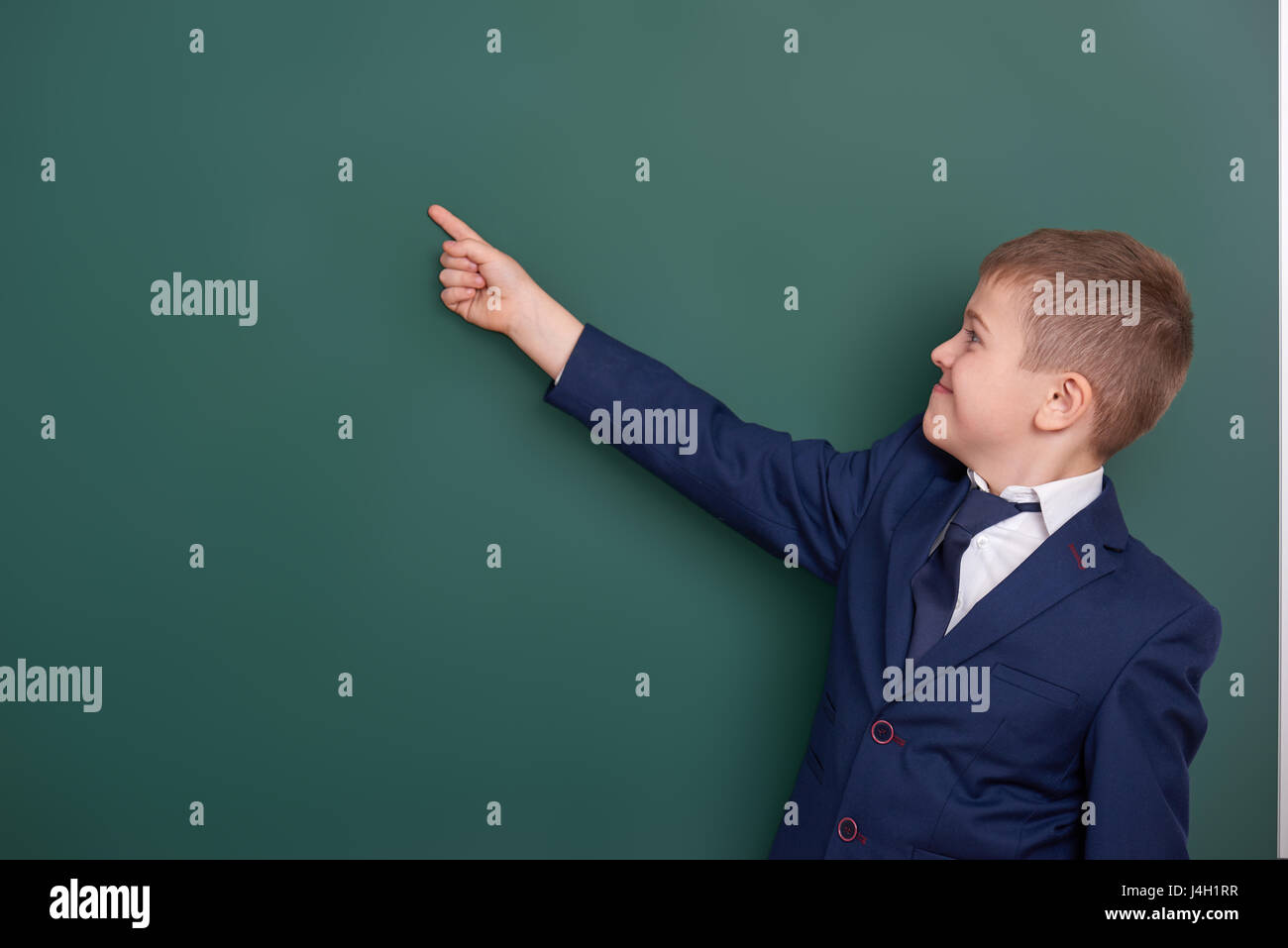 school boy point the finger near blank chalkboard background, dressed ...