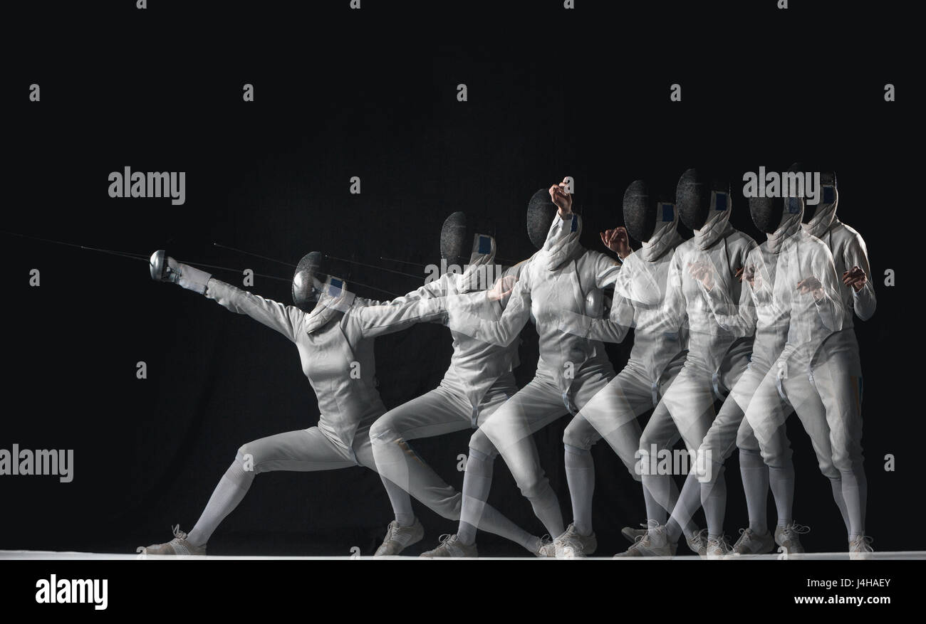 Full-length portrait of woman wearing white fencing costume on black ...
