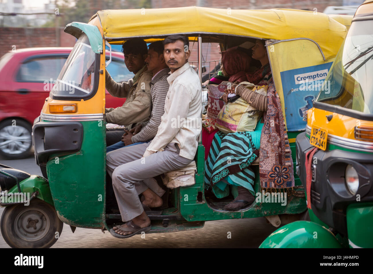 Indian men and women traveling in a taxi cab in downtown Agra, India ...