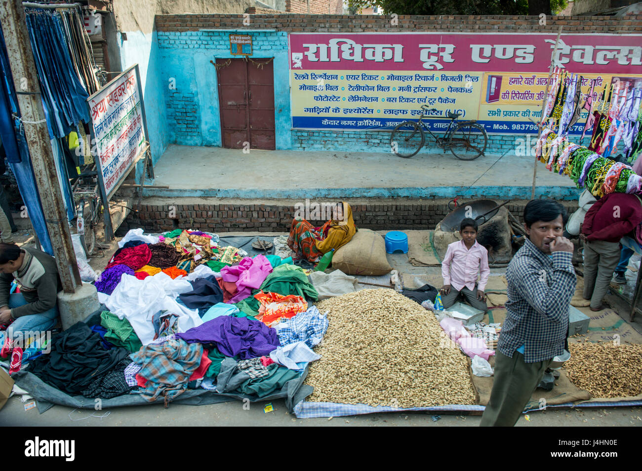 Clothing and fresh grains are for sale at an open air market in ...