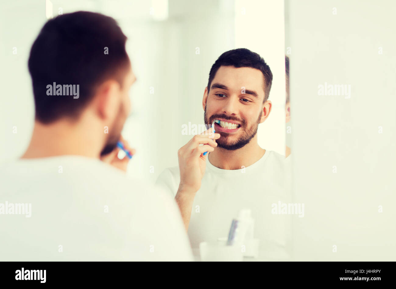 man with toothbrush cleaning teeth at bathroom Stock Photo - Alamy