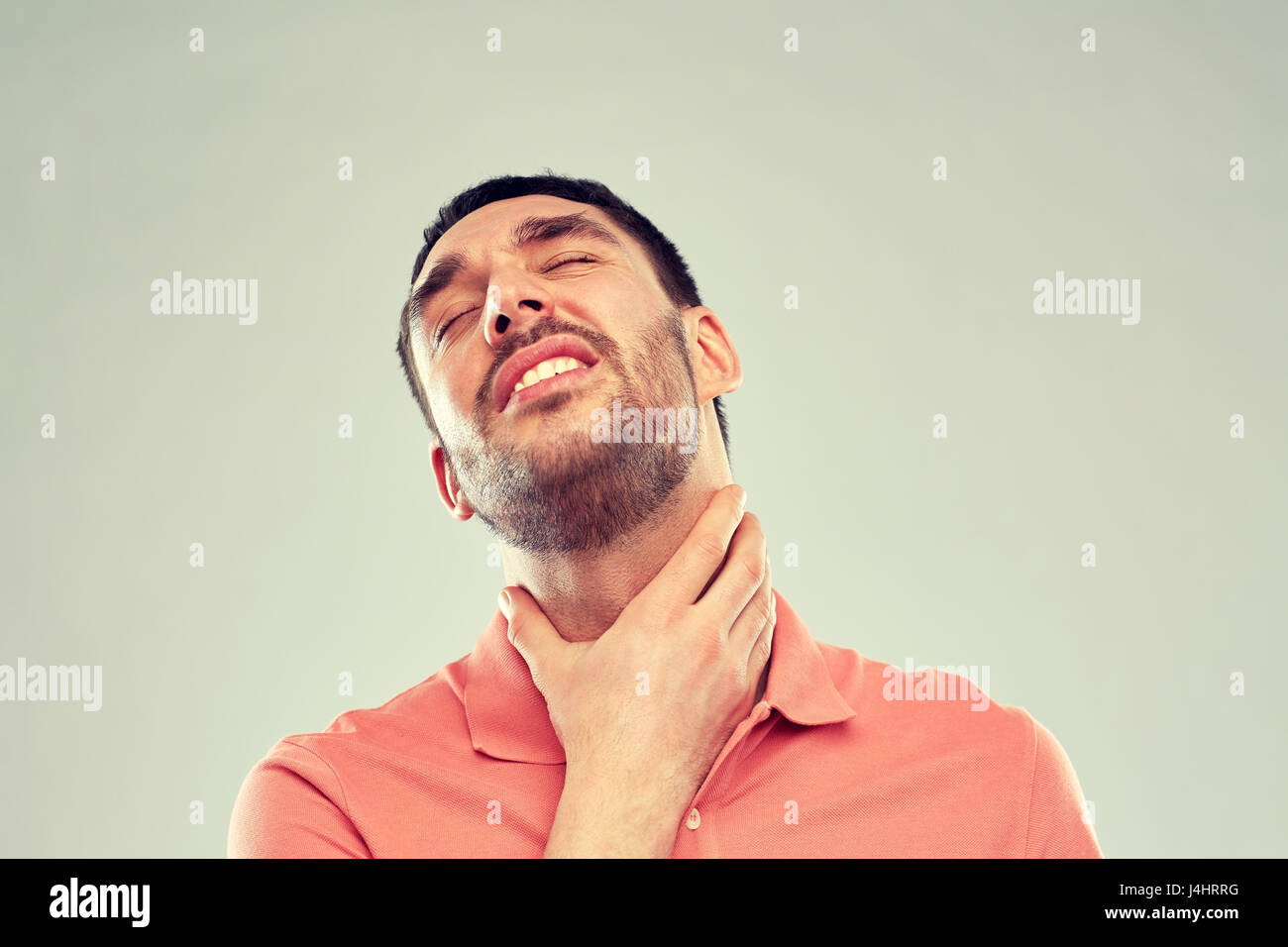 man touching neck and suffering from throat pain Stock Photo - Alamy