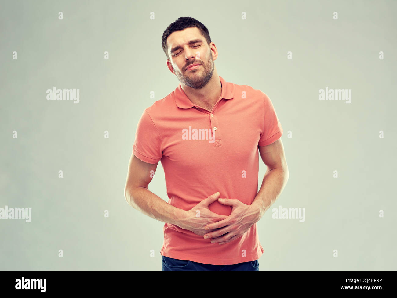 unhappy man suffering from stomach ache Stock Photo - Alamy