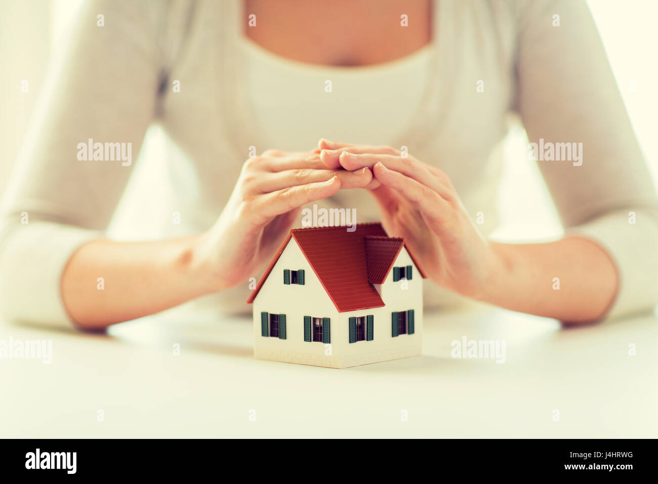 close up of hands protecting house or home model Stock Photo - Alamy