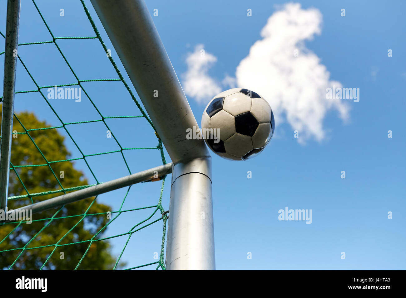 soccer ball flying into football goal net over sky Stock Photo - Alamy