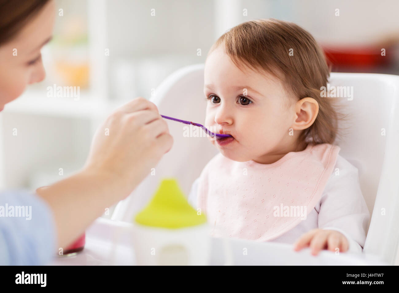 happy mother feeding baby with puree at home Stock Photo - Alamy
