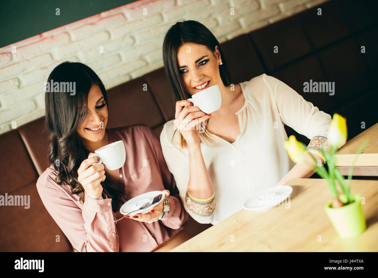 Two friends relaxing and drinking coffee Stock Photo - Alamy