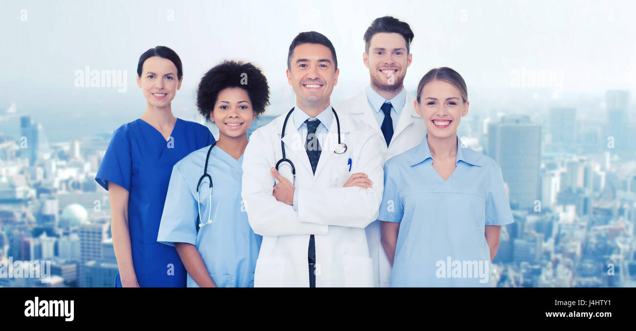group of happy doctors over blue background Stock Photo - Alamy