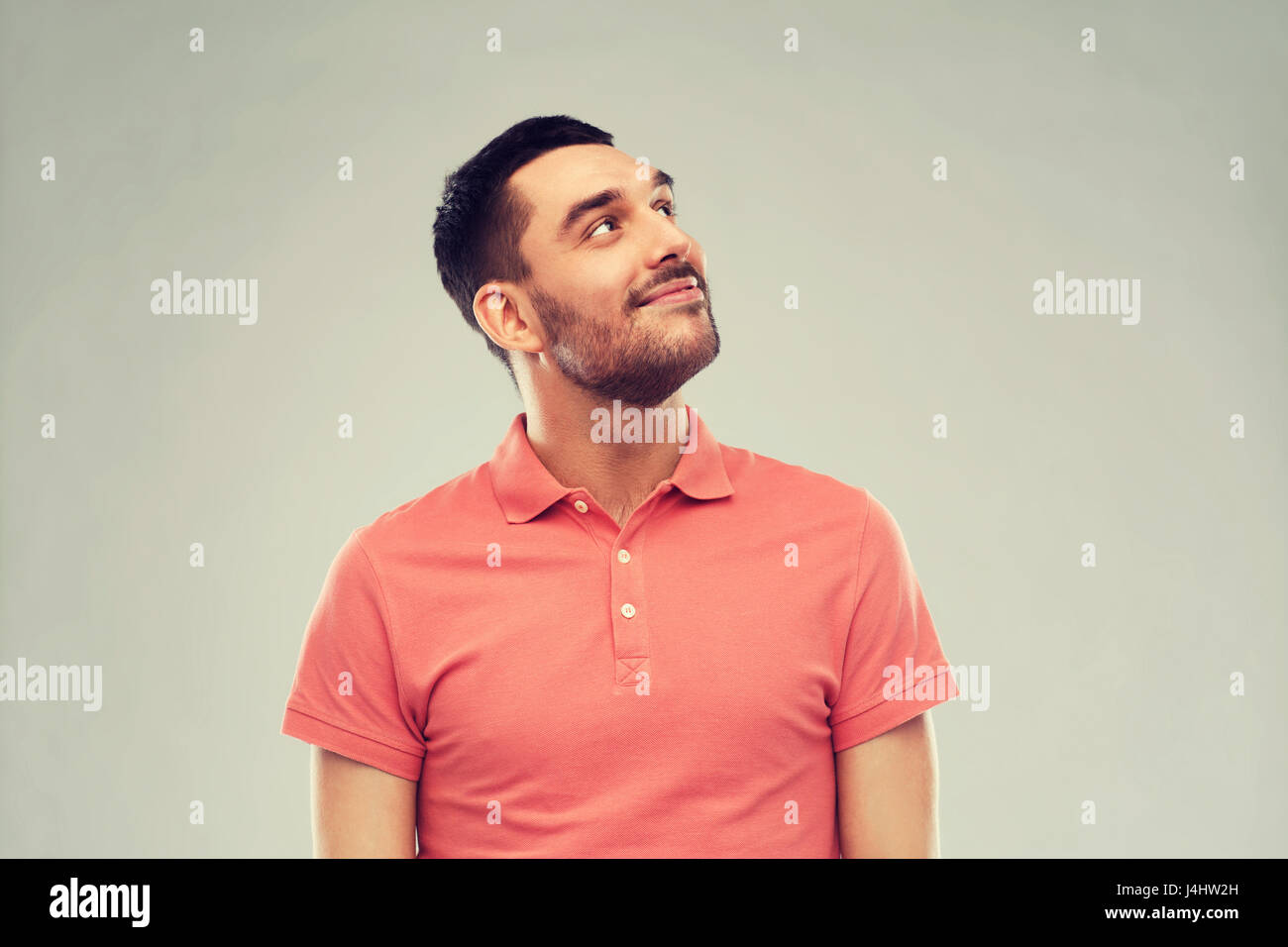 smiling man looking up over gray background Stock Photo - Alamy
