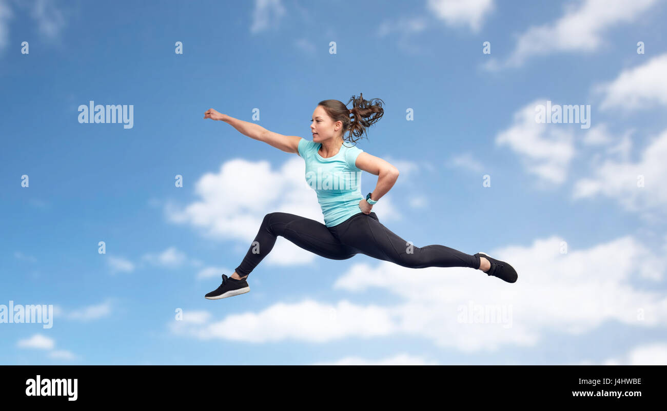 happy sporty young woman jumping in fighting pose Stock Photo - Alamy